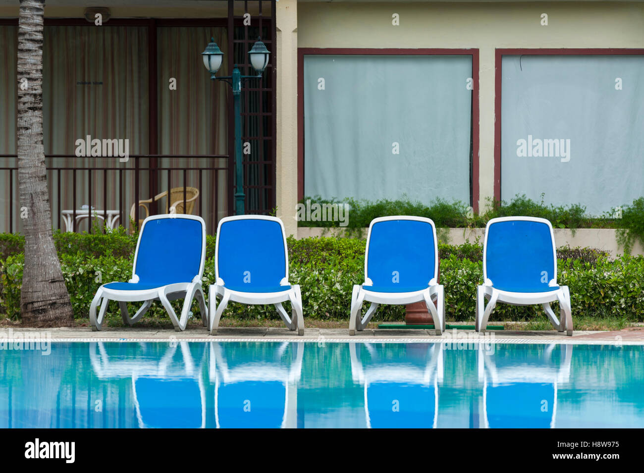 Reclining pool chairs poolside on hotel pool Stock Photo - Alamy