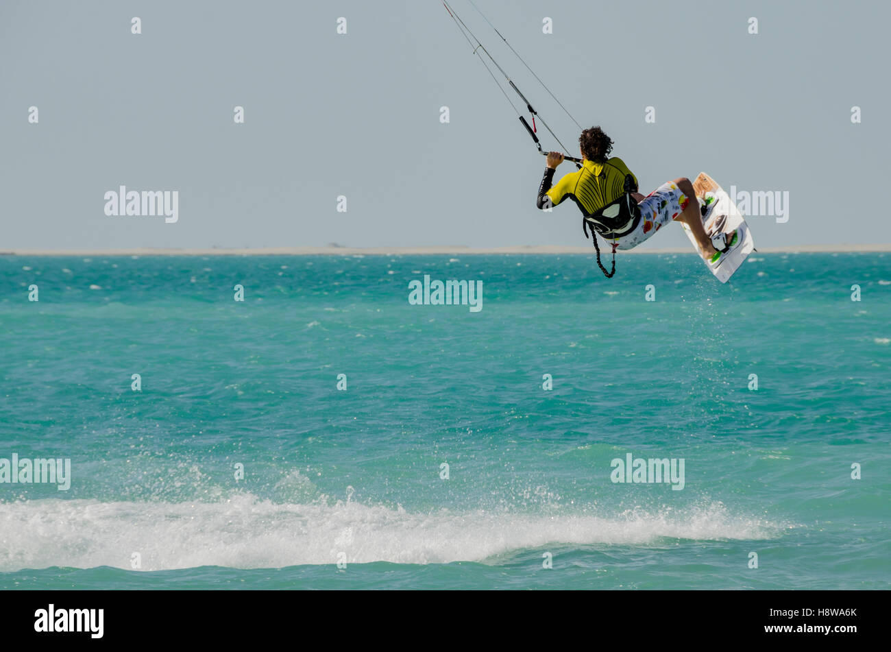 Kite surfer catching air over turquoise blue sea Stock Photo - Alamy
