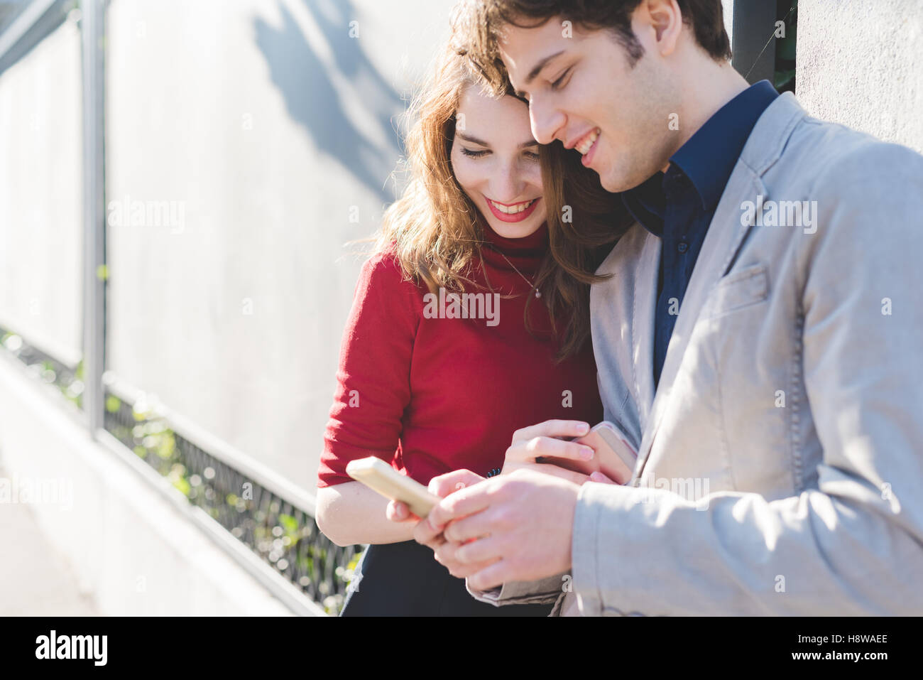 Young beautiful couple in love using smart phone together outdoor in ...