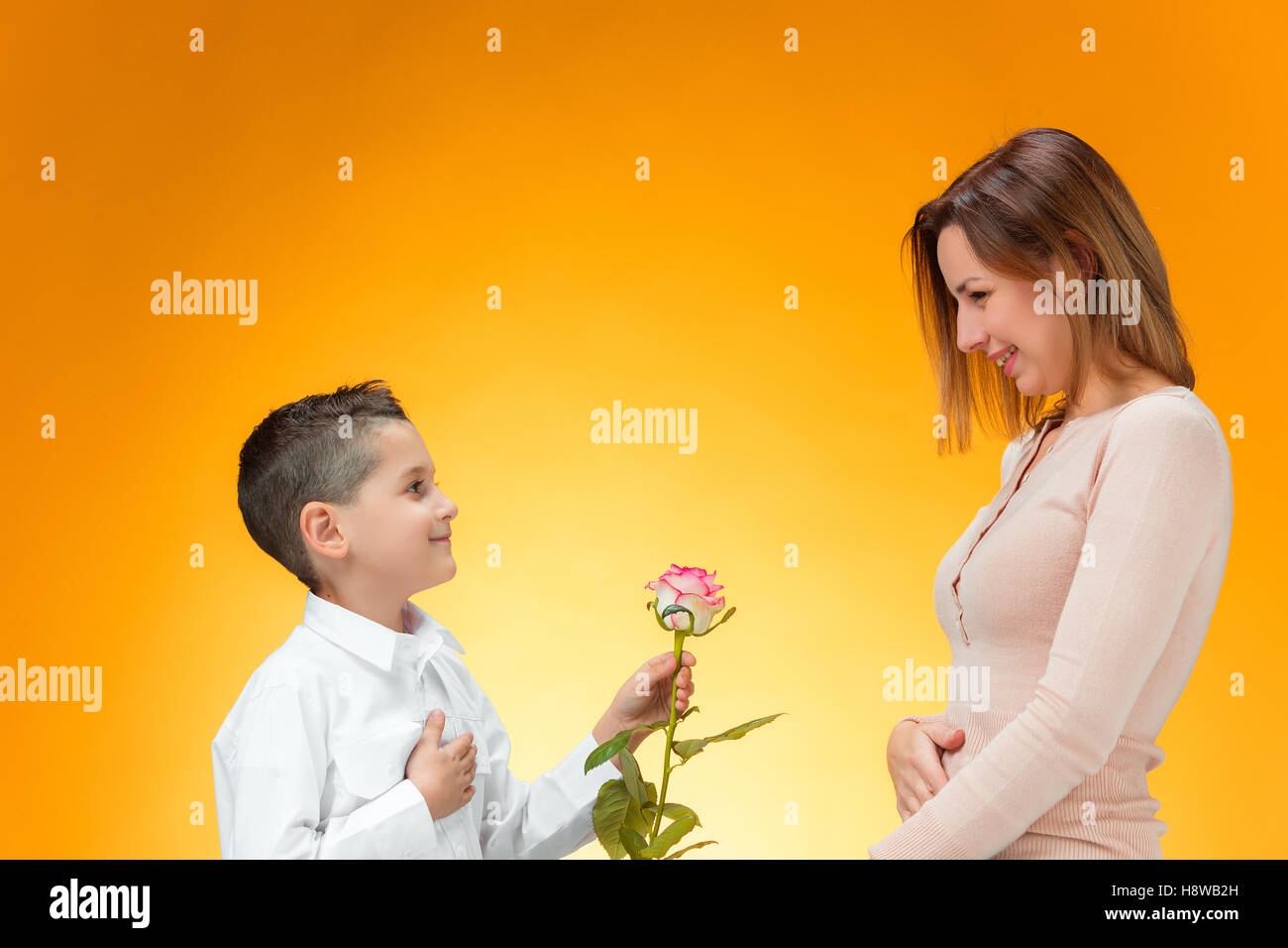 Young kid giving red rose to his mom Stock Photo - Alamy