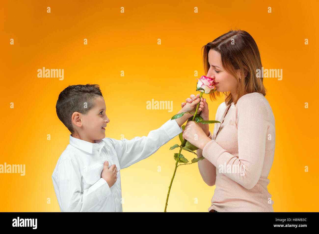 Young kid giving red rose to his mom Stock Photo - Alamy