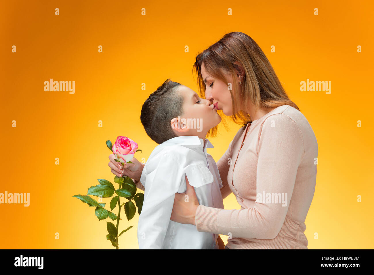 Young kid giving red rose to his mom Stock Photo - Alamy