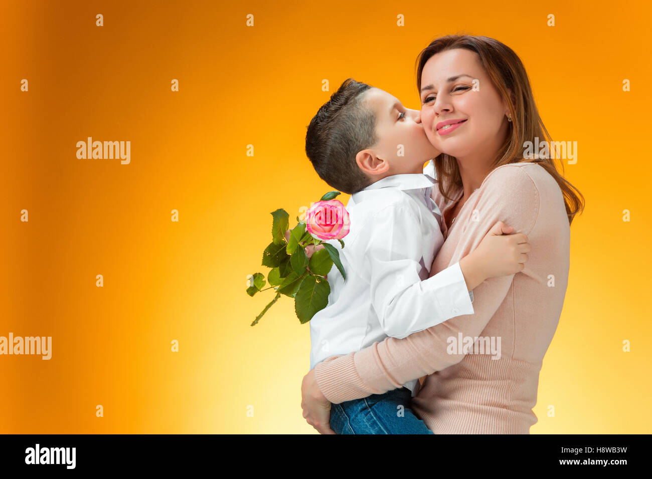 Young kid giving red rose to his mom Stock Photo - Alamy