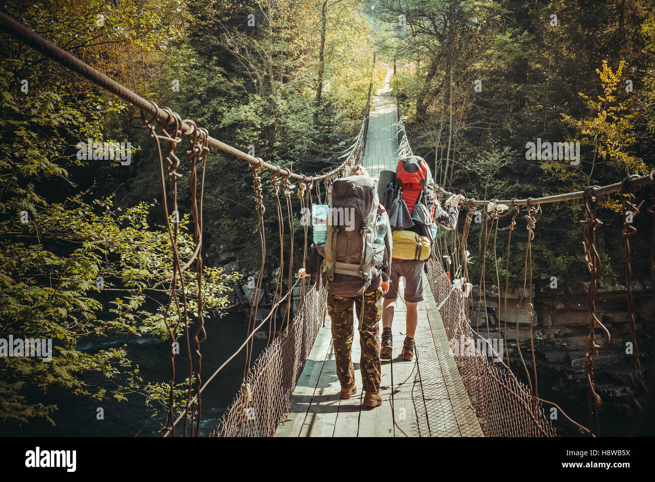 Travelers crossing through hanging bridge Stock Photo - Alamy