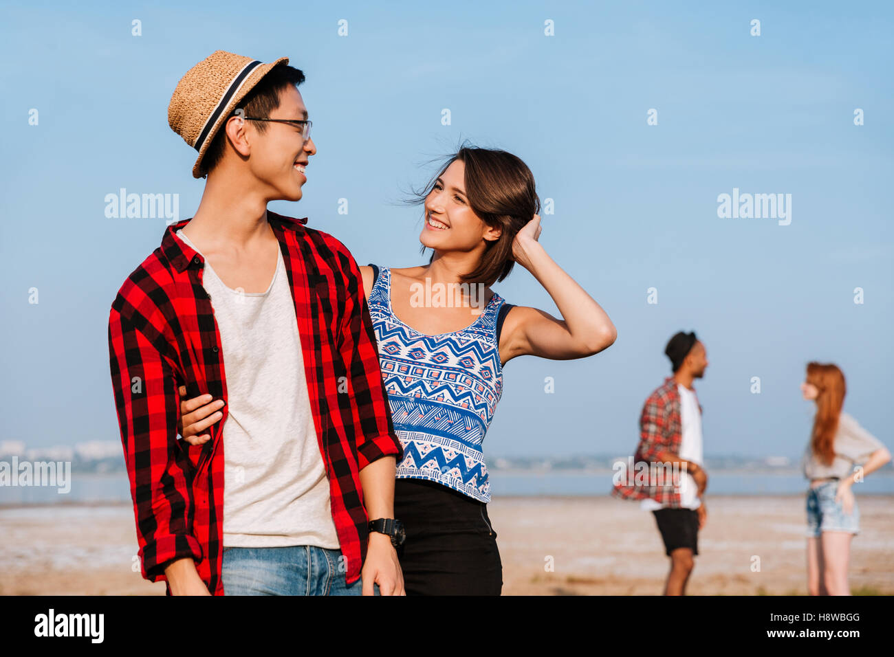 Two happy young couples standing and smiling outdoors Stock Photo - Alamy
