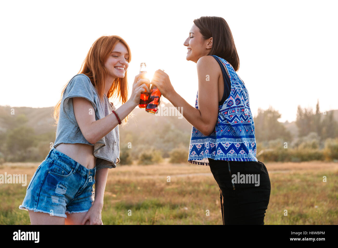 Smiling women drinking soda together hi-res stock photography and ...