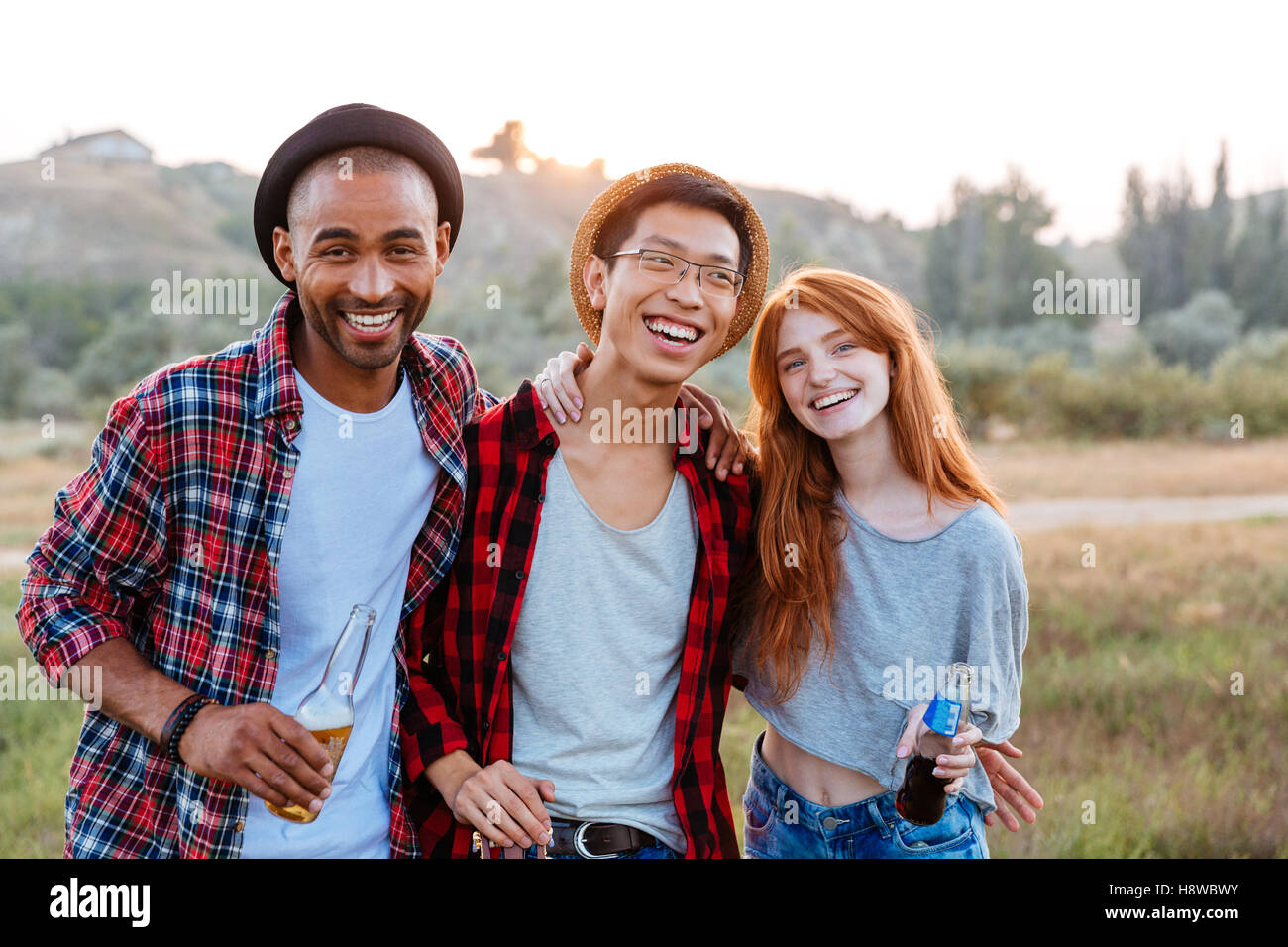 Smiling friends hugging outdoors hi-res stock photography and images ...