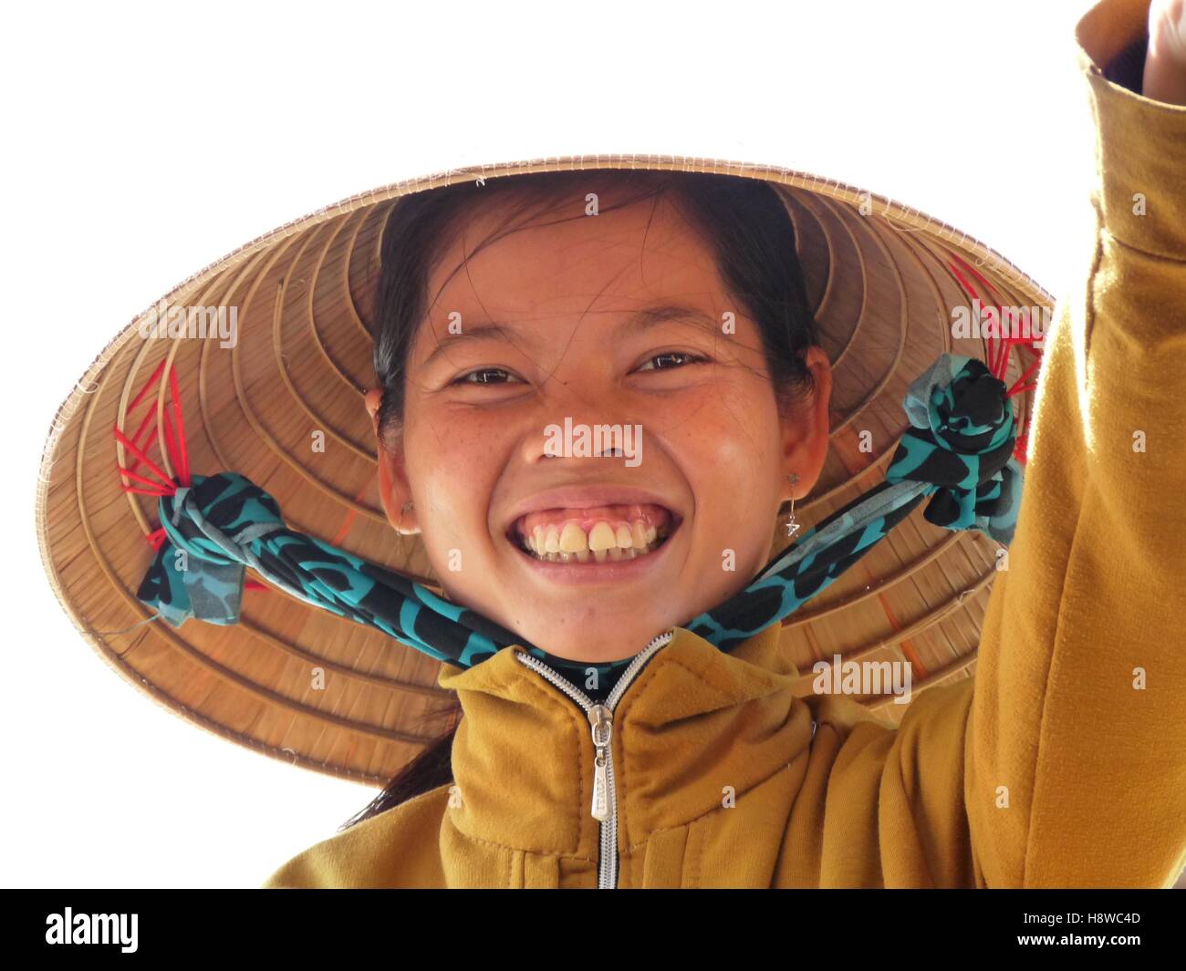 Close up of smiling Vietnamese girl in typical conical hat working on ...