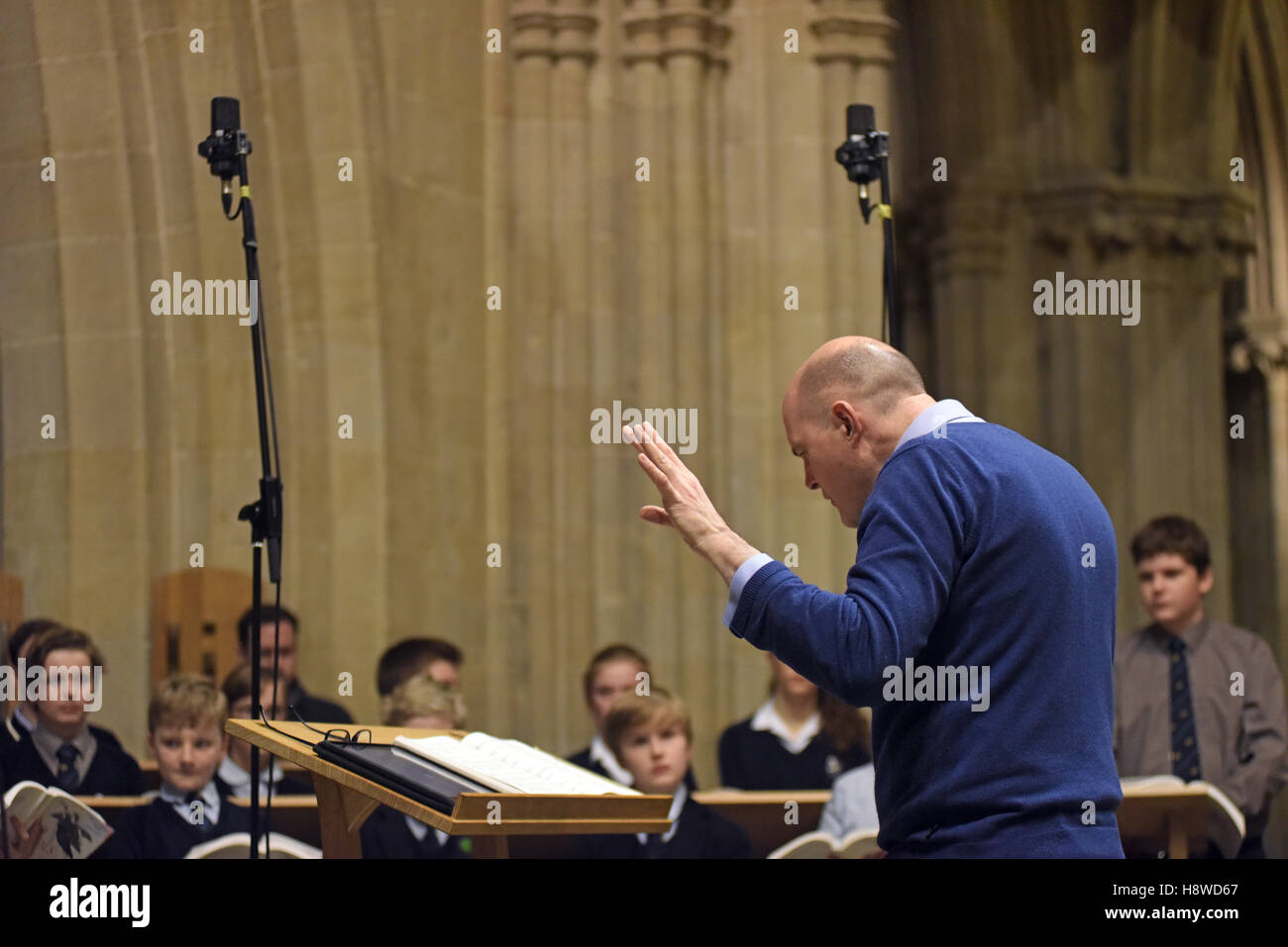 Choristers being conducted by choir master at a recording session for a ...