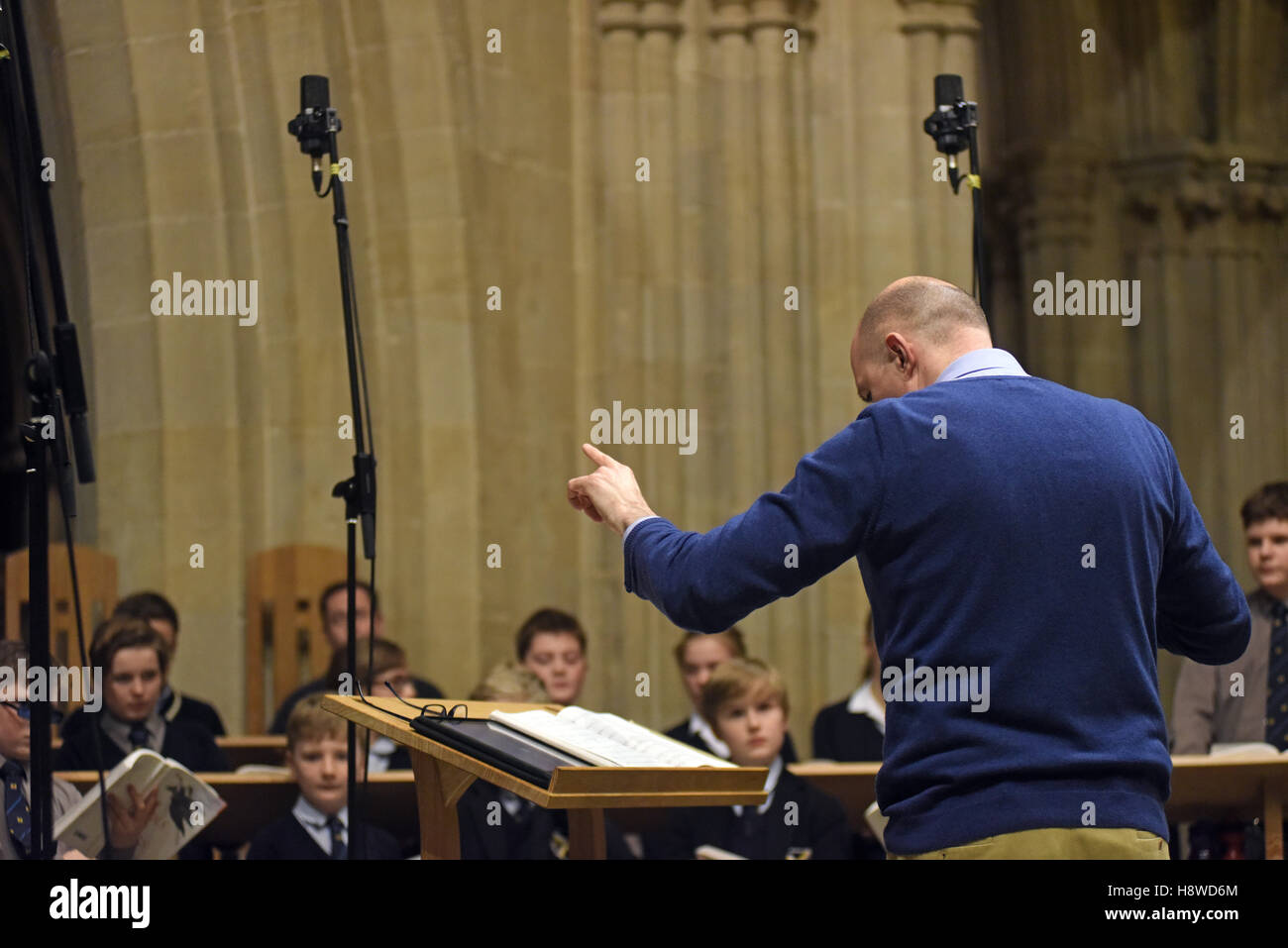 Choristers being conducted by choir master at a recording session for a ...