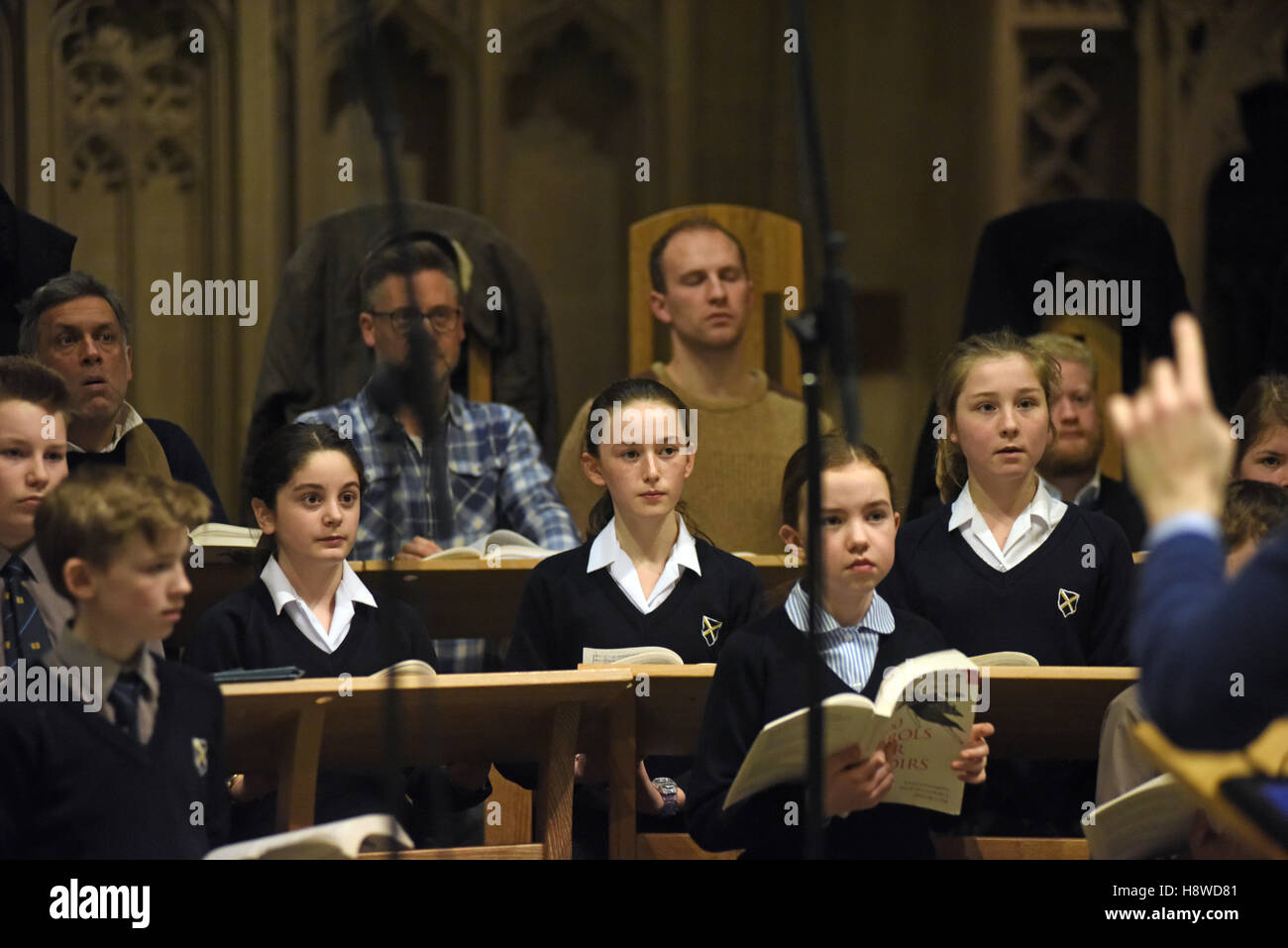 Choristers being conducted by choir master at a recording session for a ...