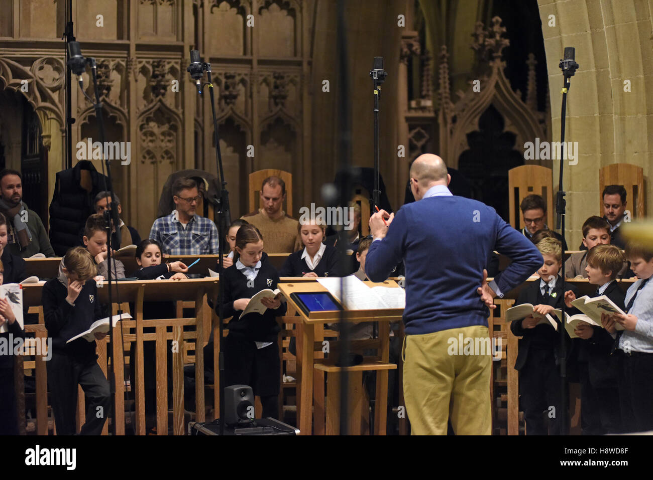 Choristers being conducted by choir master at a recording session for a ...