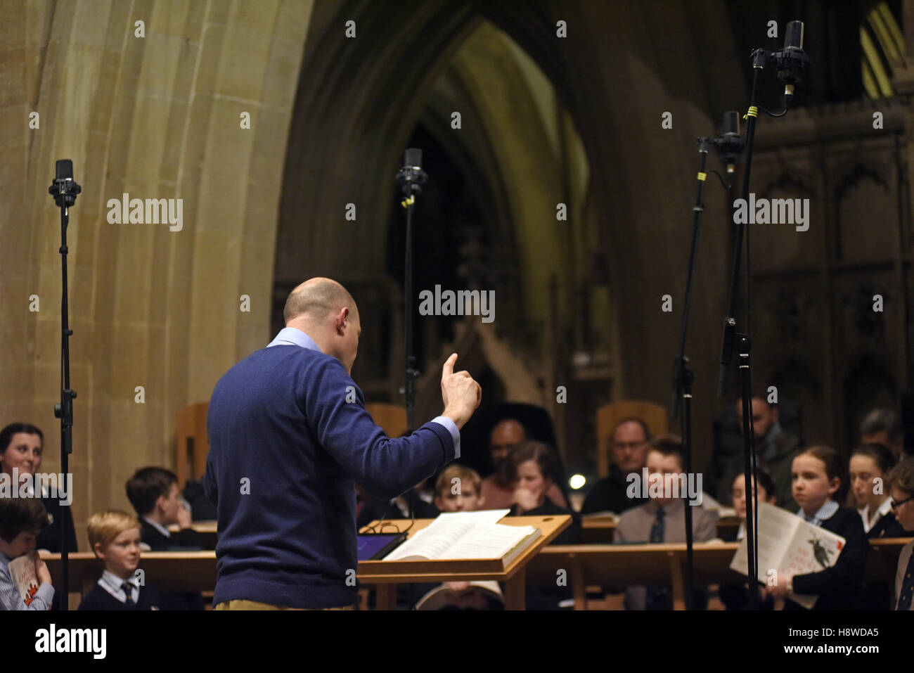 Choristers being conducted by choir master at a recording session for a ...