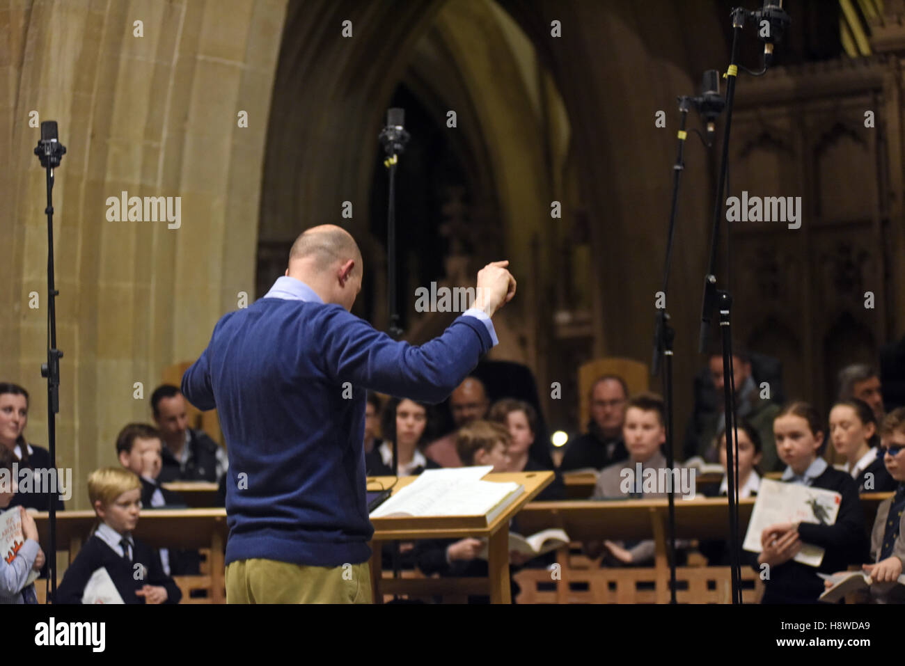 Choristers being conducted by choir master at a recording session for a ...