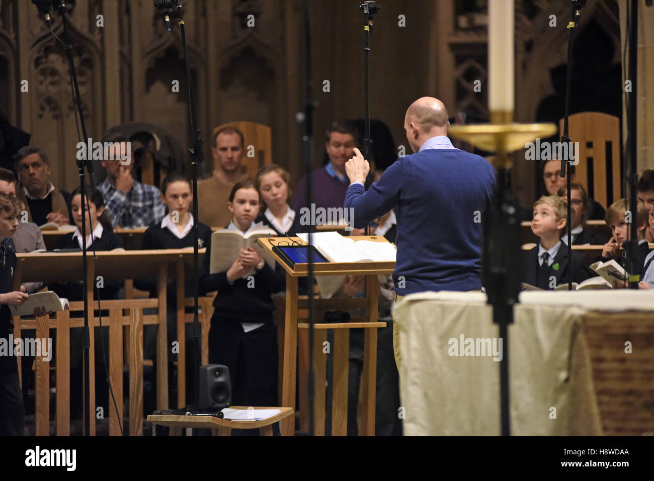 Choristers being conducted by choir master at a recording session for a ...