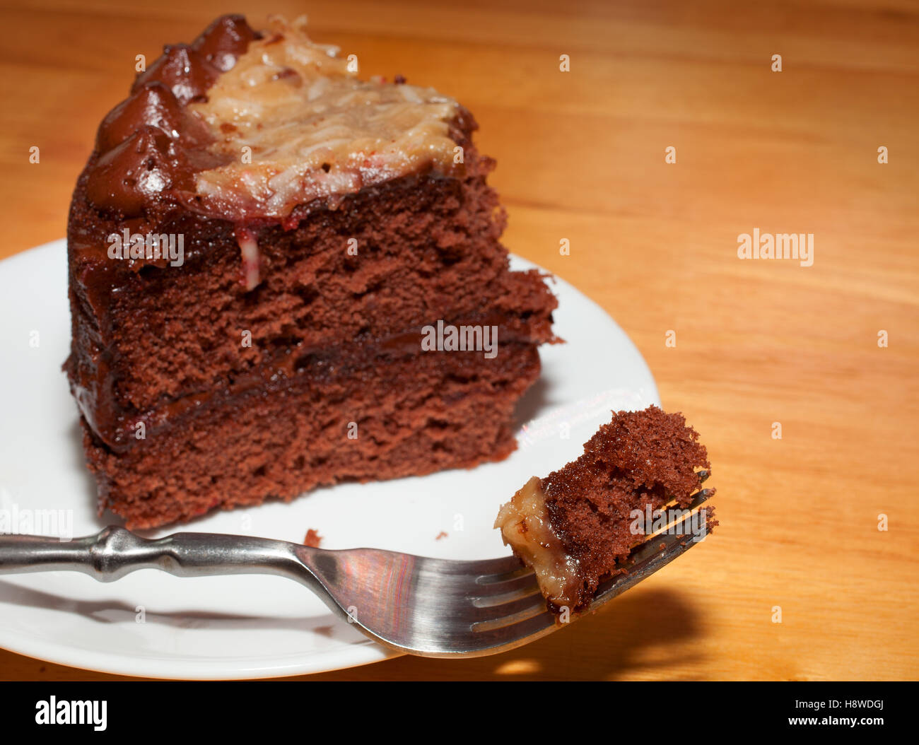 Fork full from a chocolate cake with pineapple frosting on a white ...