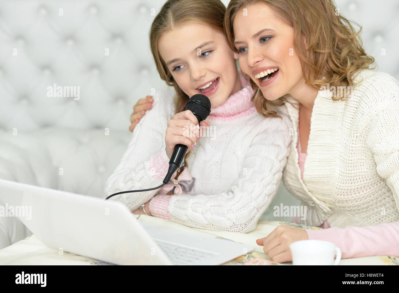Mother and daughter singing karaoke Stock Photo - Alamy