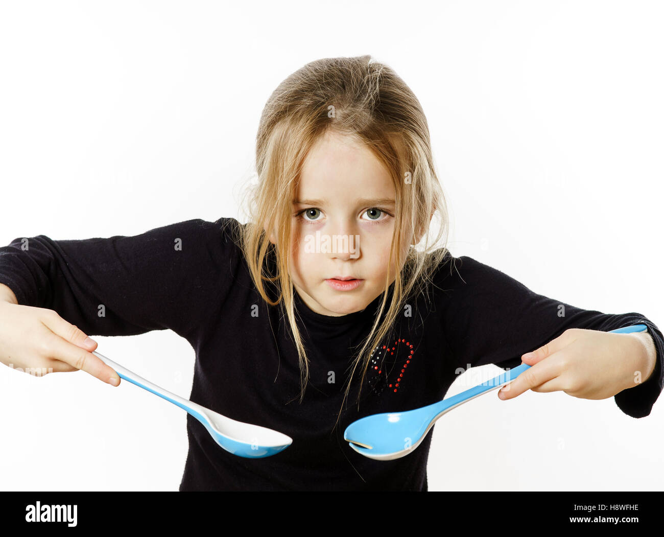 Preschooler girl playing with spoons for salad, isolated on white ...