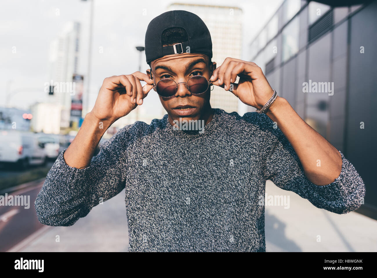 Young handsome american african swag man outdoor in the city looking in ...