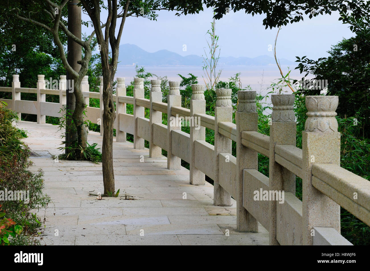 A curved walkway and stone railing on the island of Putuoshan located ...