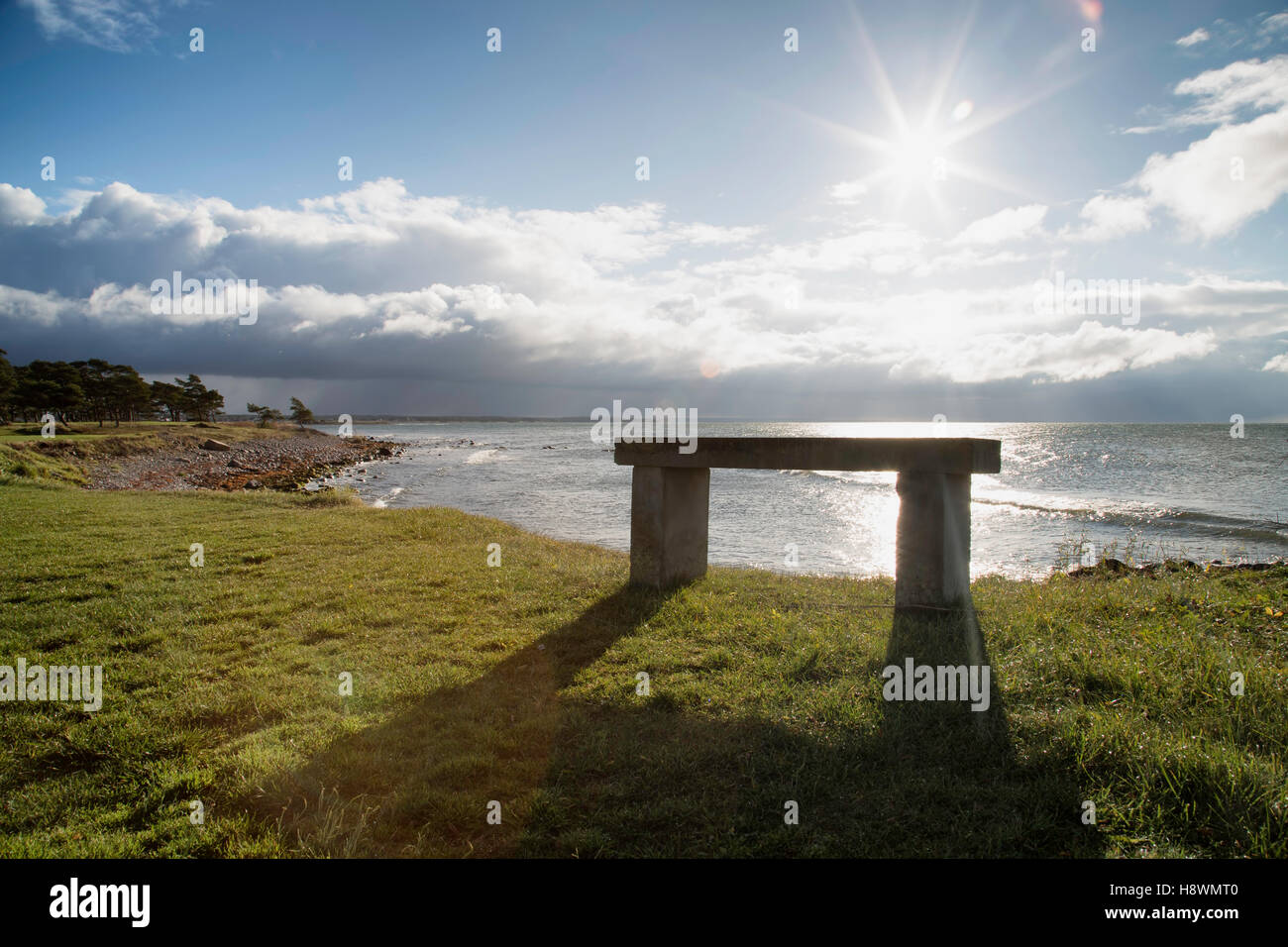 Bench with Ocean and a cloudy sky Stock Photo - Alamy