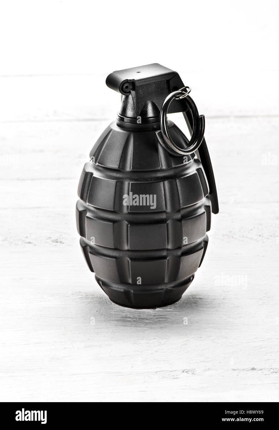 Grenade standing upright with the pin safely in position on a white ...