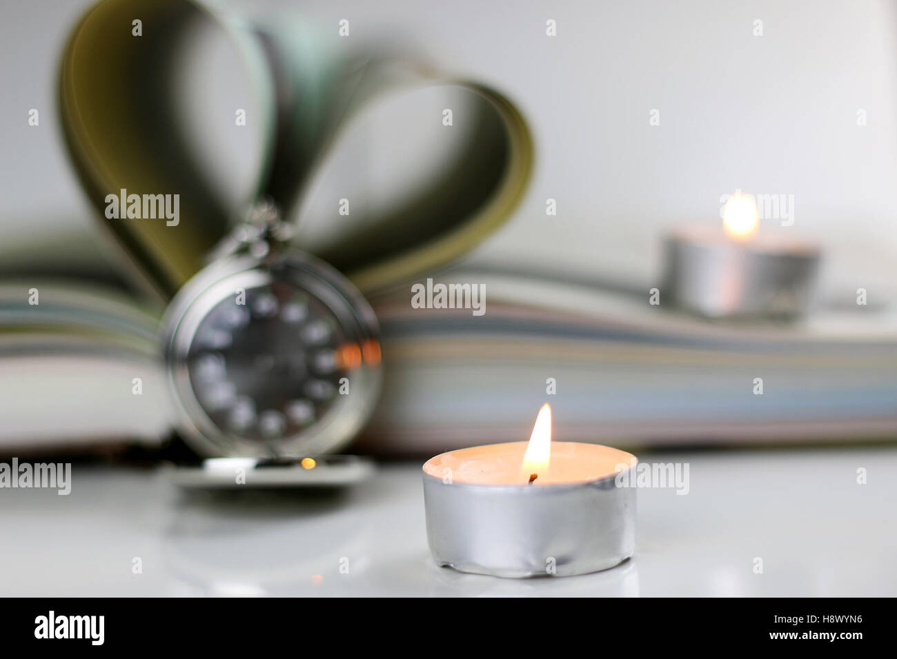 book pocket watch candles Stock Photo - Alamy