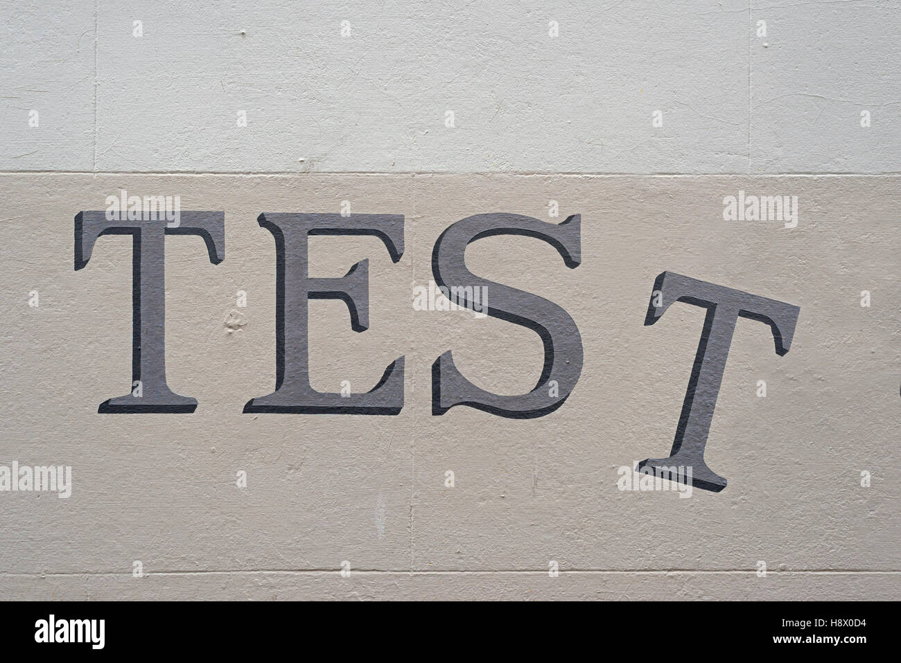 The word "TEST" painted in a serif handwriting type on a wall Stock ...