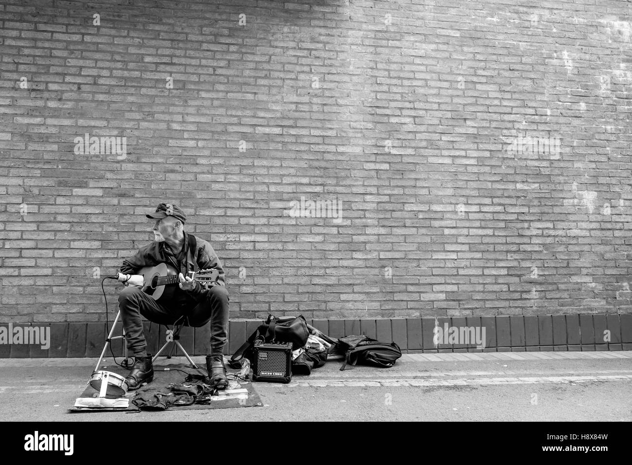 Busking Cambridge guitar pan handling brick wall old man hat solitary ...
