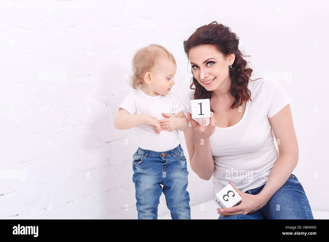 Mother and daughter play cubes. On dice have digits. Family education ...