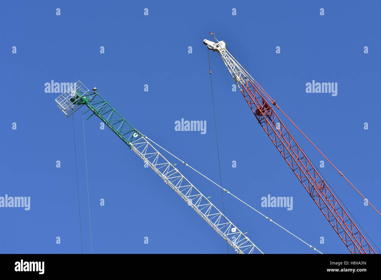 Steel tower-crane arms against blue sky background Stock Photo - Alamy