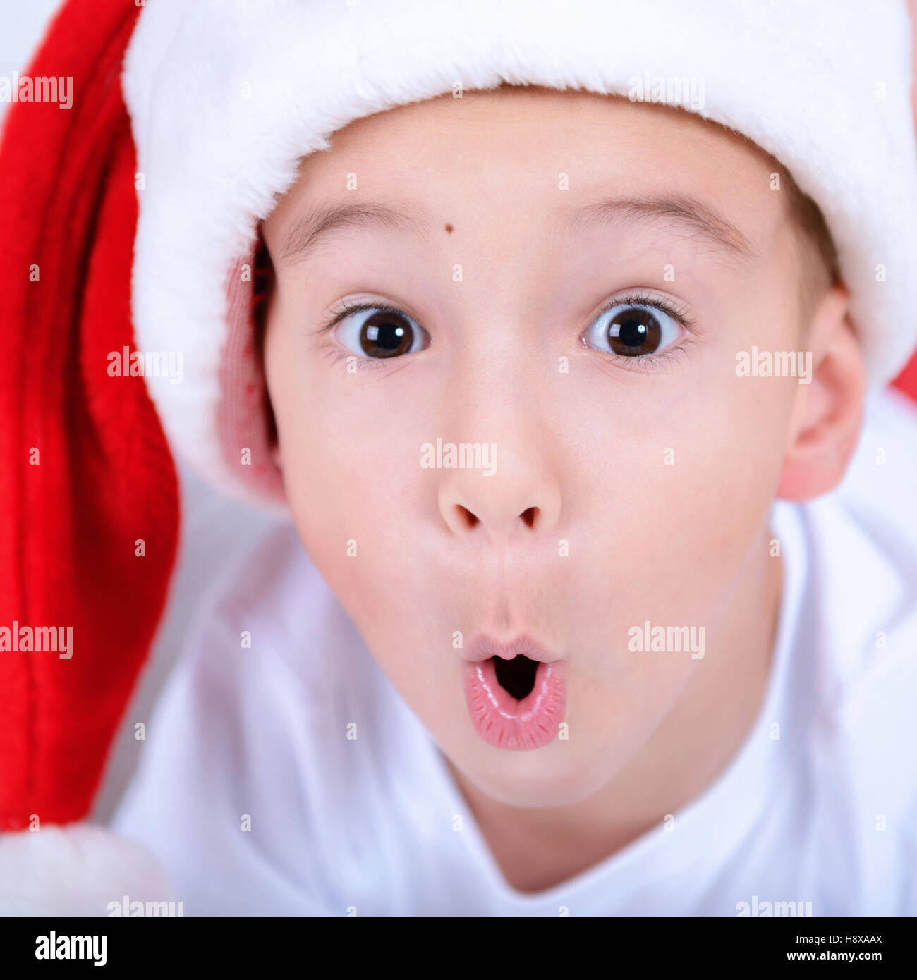 Christmas portrait of a child. Face surprised little boy in a cap of ...