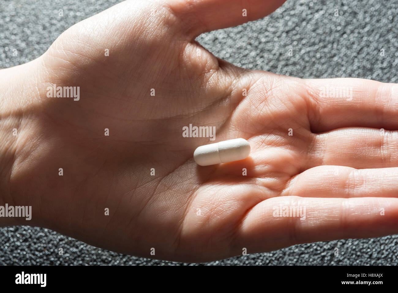 Bare hand holding one white medicinal tablet Stock Photo - Alamy