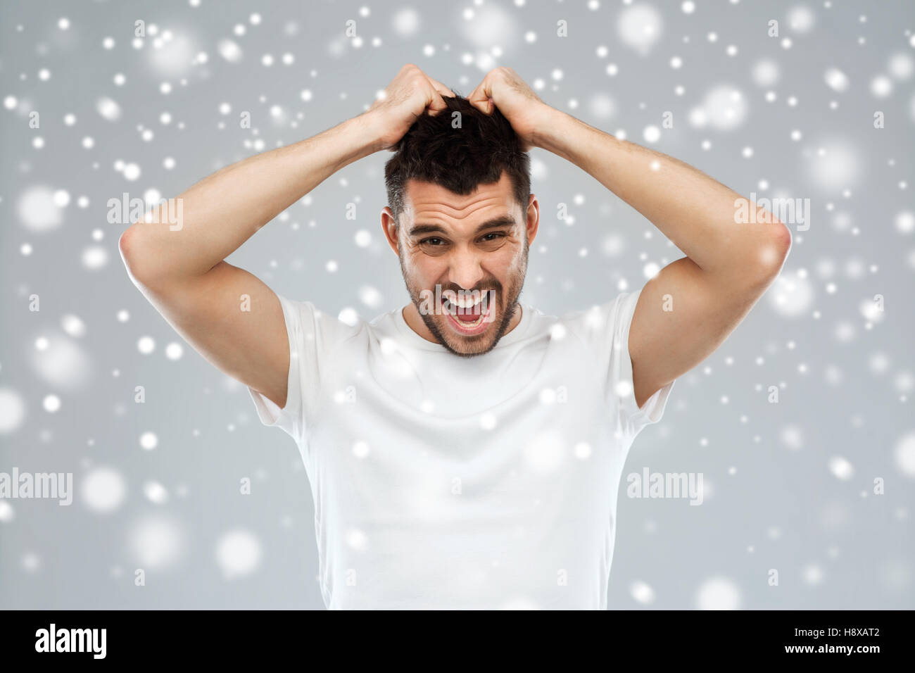 crazy shouting man in t-shirt over snow background Stock Photo - Alamy