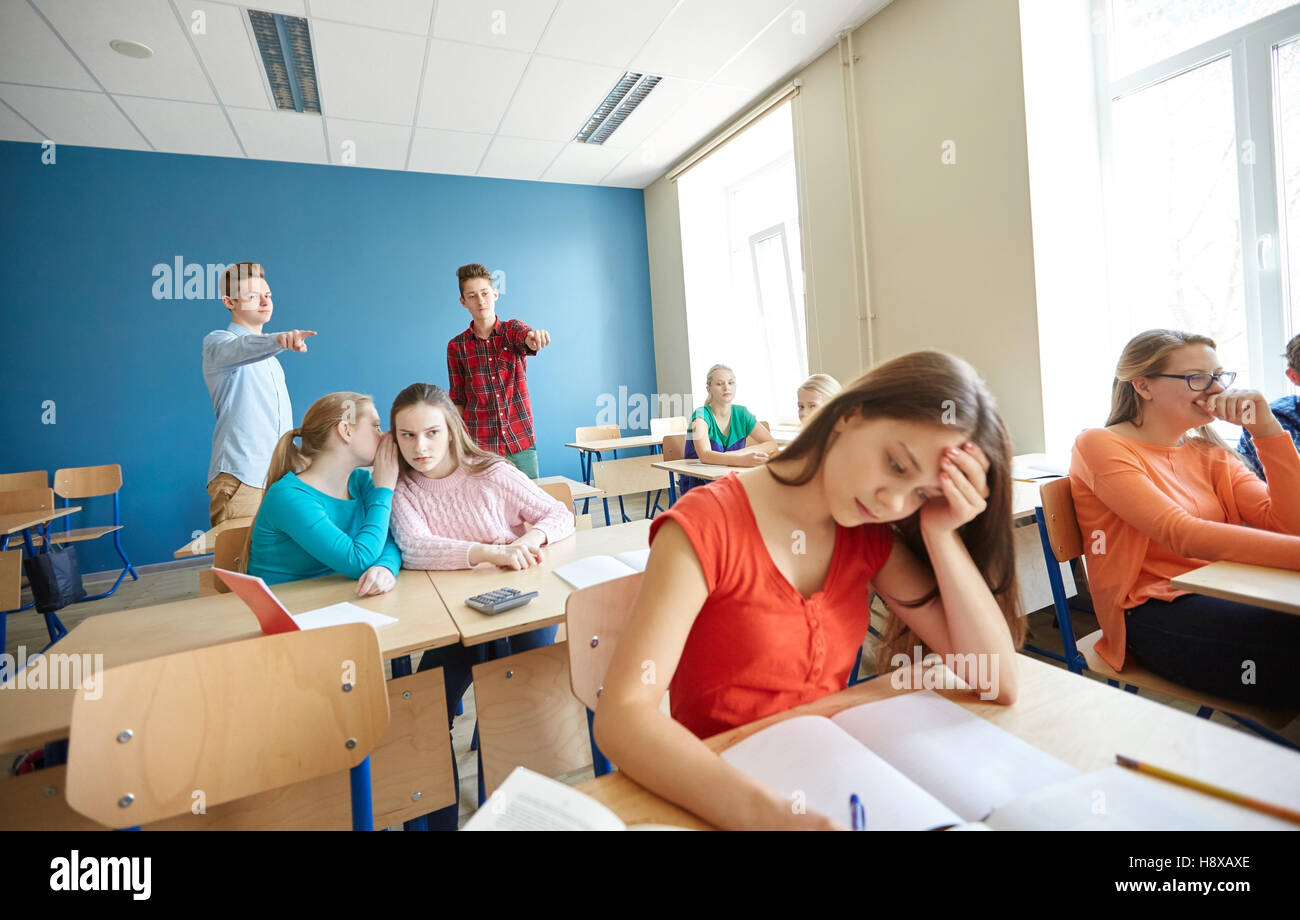 students gossiping behind classmate back at school Stock Photo - Alamy