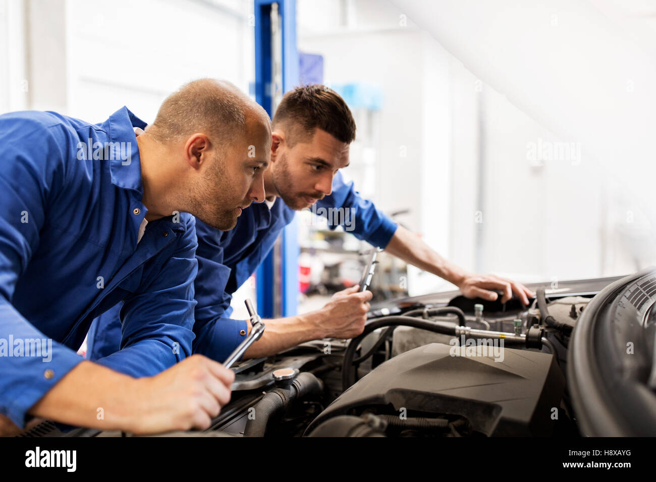 mechanic men with wrench repairing car at workshop Stock Photo - Alamy