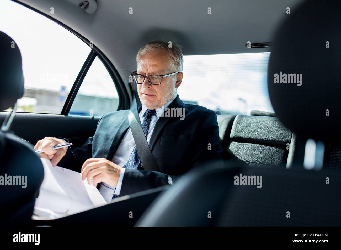 senior businessman with papers driving in car Stock Photo - Alamy