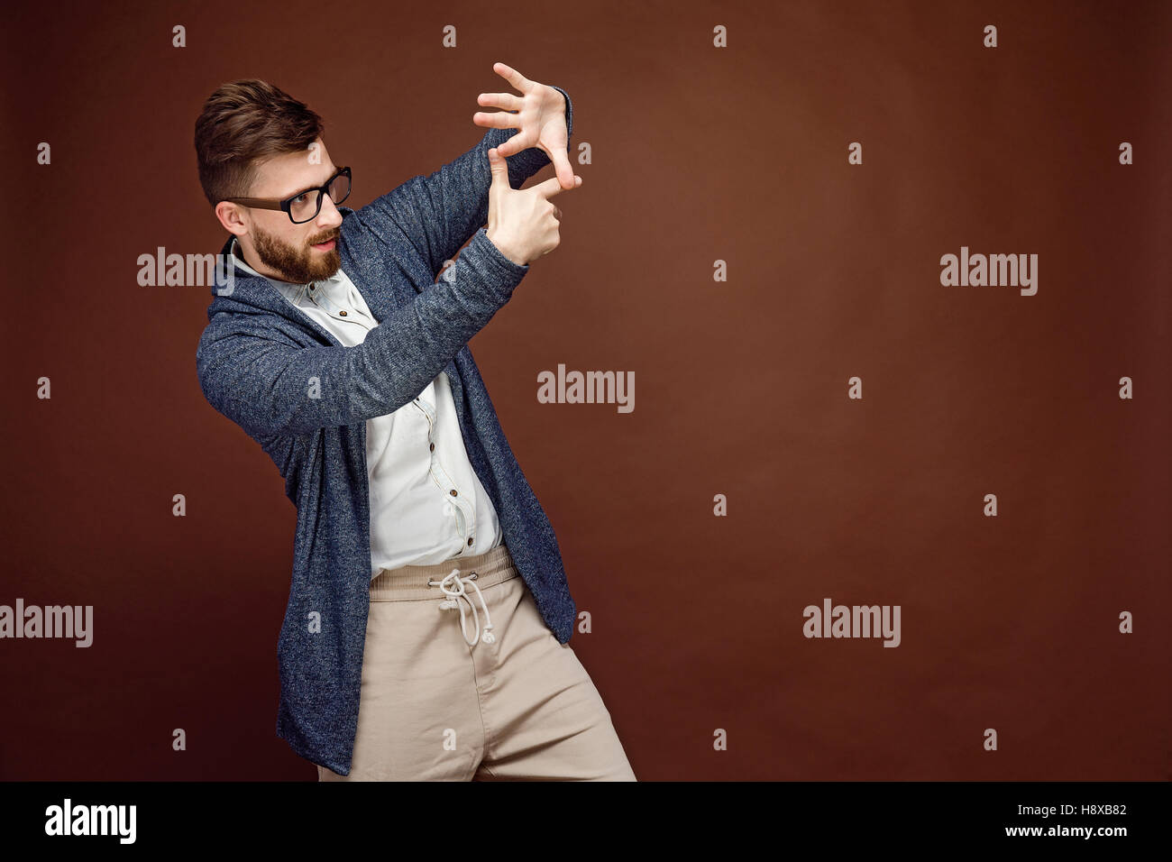 Male making camera gesture in studio Stock Photo - Alamy