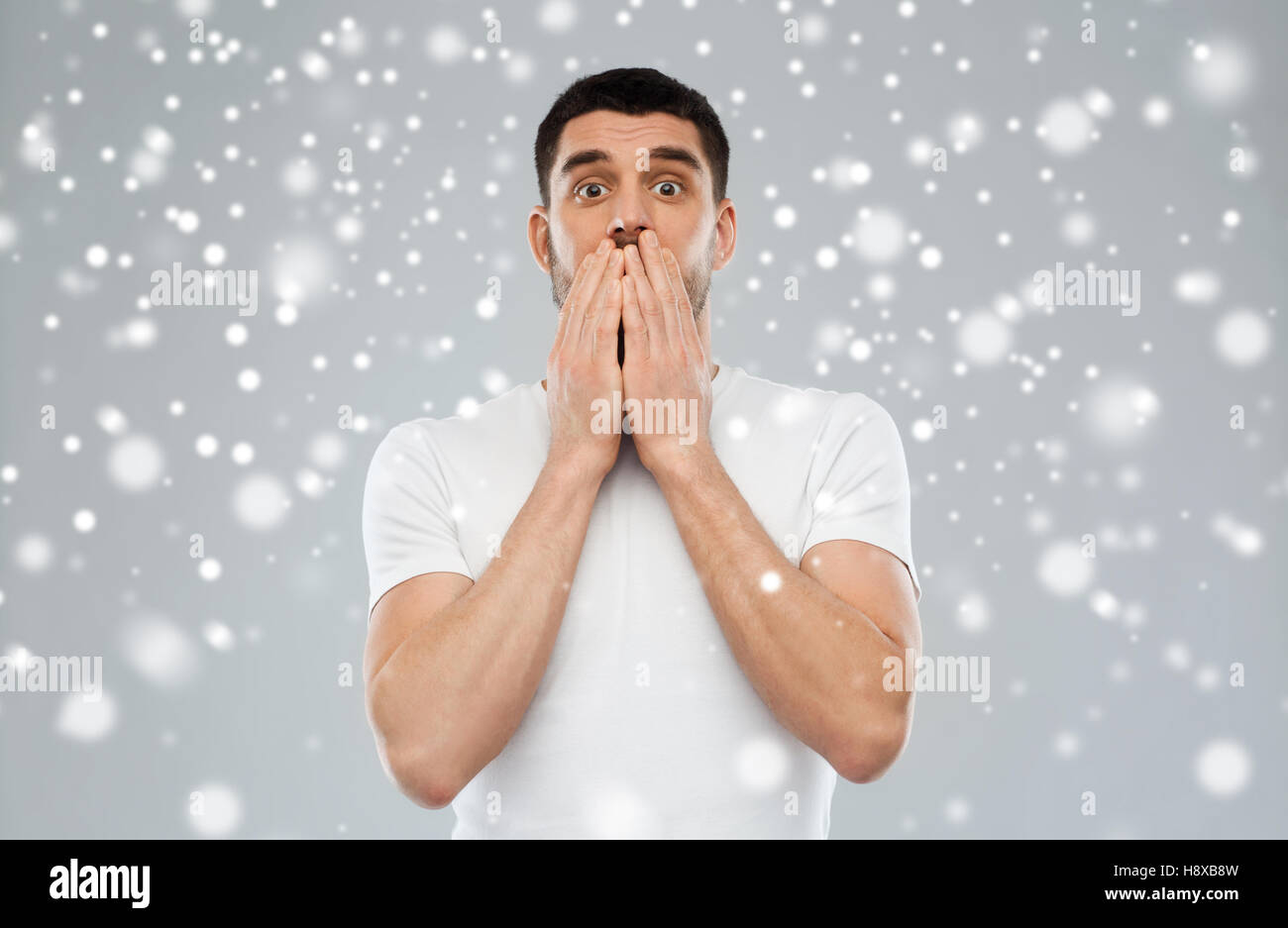 scared man in white t-shirt over snow background Stock Photo - Alamy