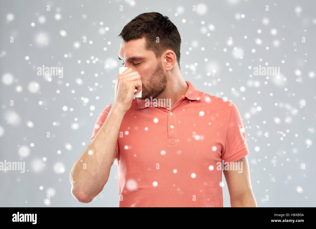sick man with paper wipe blowing nose over snow Stock Photo - Alamy