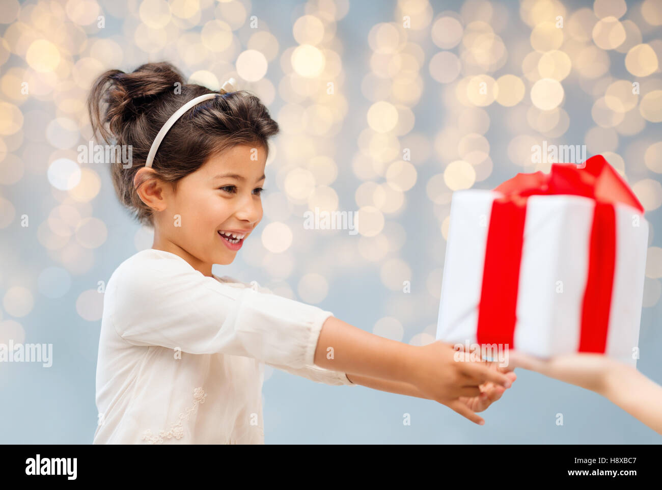 smiling little girl giving or receiving present Stock Photo - Alamy