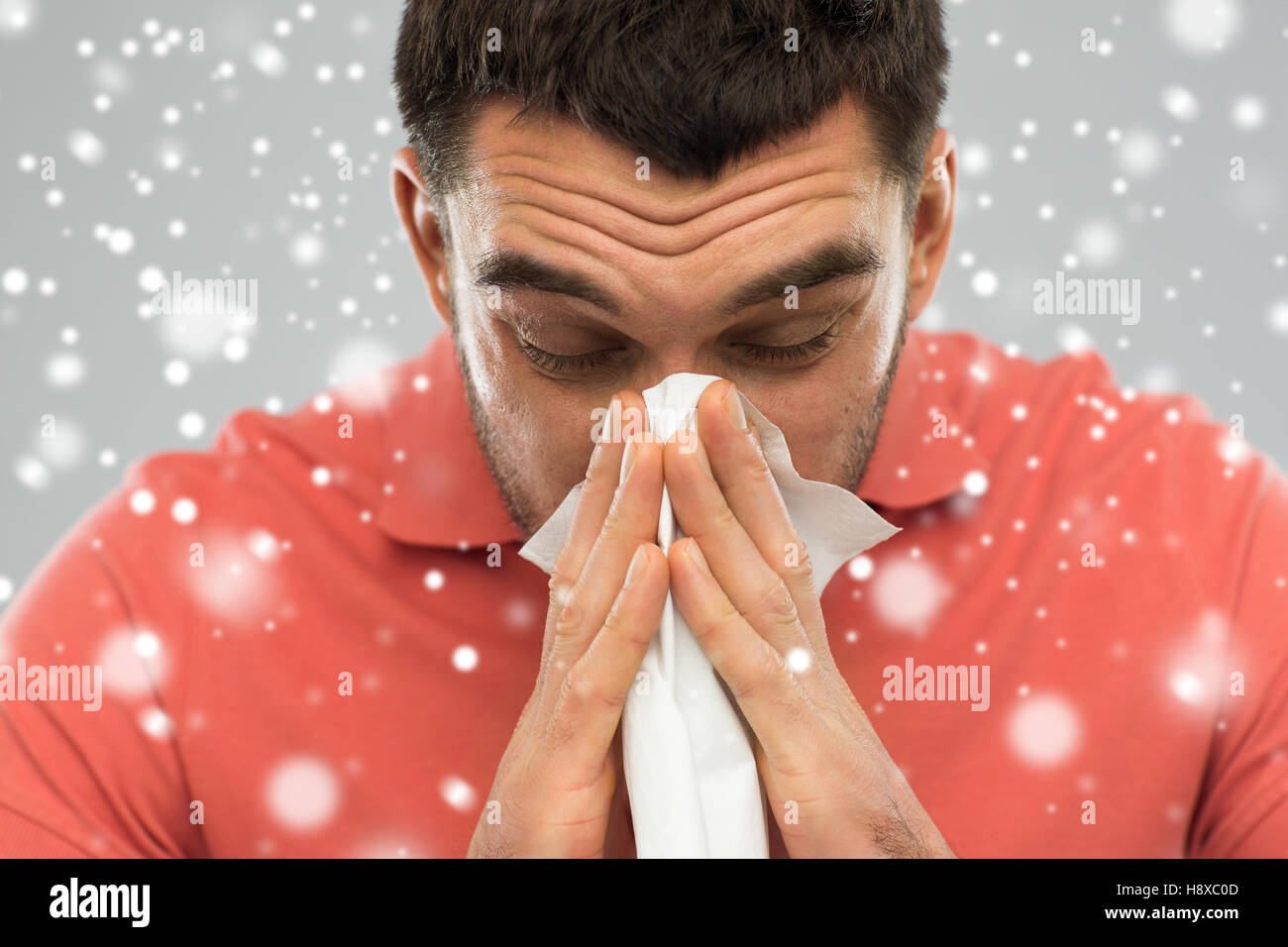 sick man with paper wipe blowing nose over snow Stock Photo - Alamy