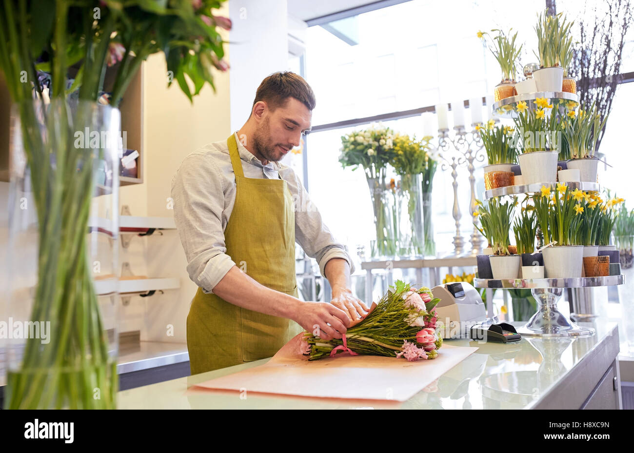 florist wrapping flowers in paper at flower shop Stock Photo - Alamy