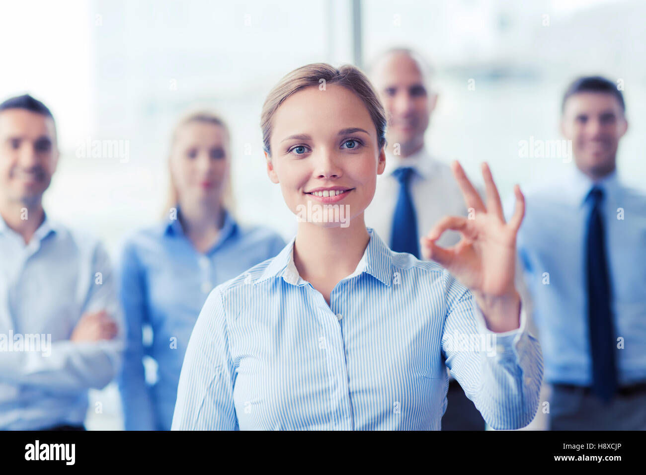 smiling businesswoman showing ok sign in office Stock Photo - Alamy