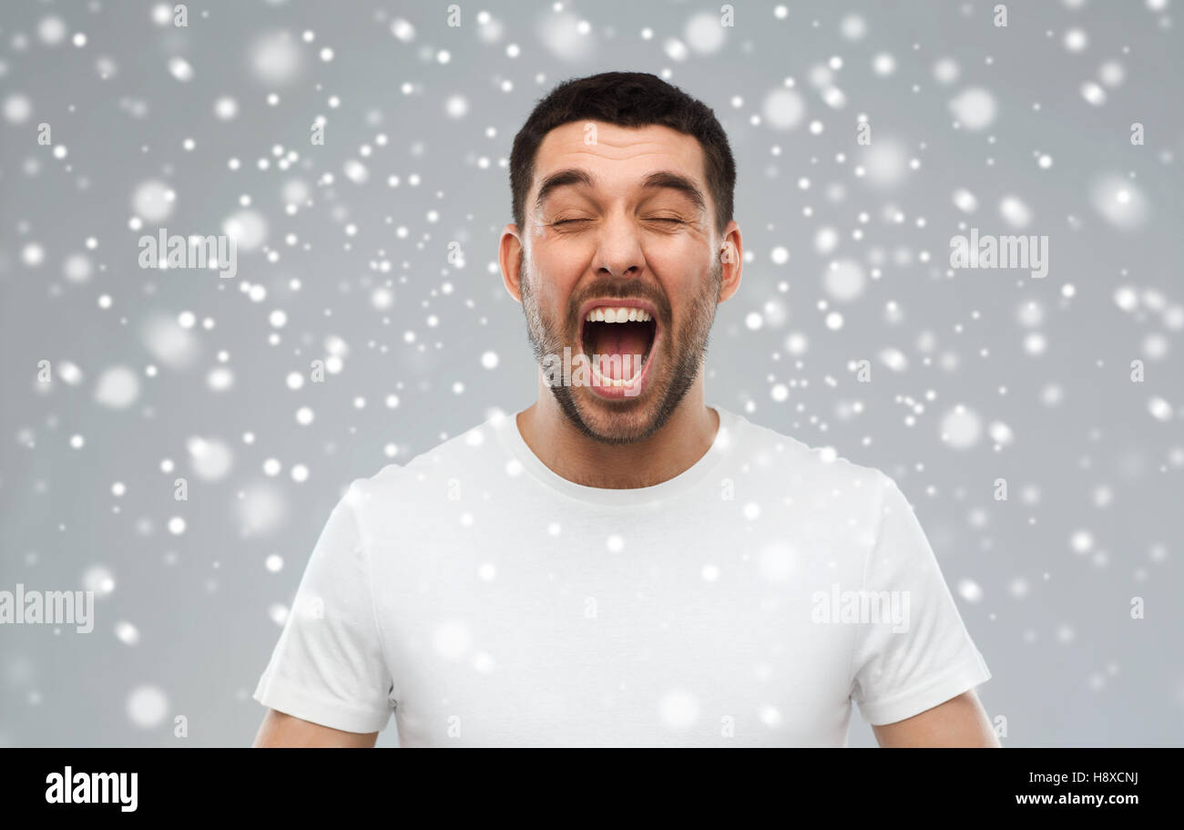 crazy shouting man in t-shirt over snow background Stock Photo - Alamy