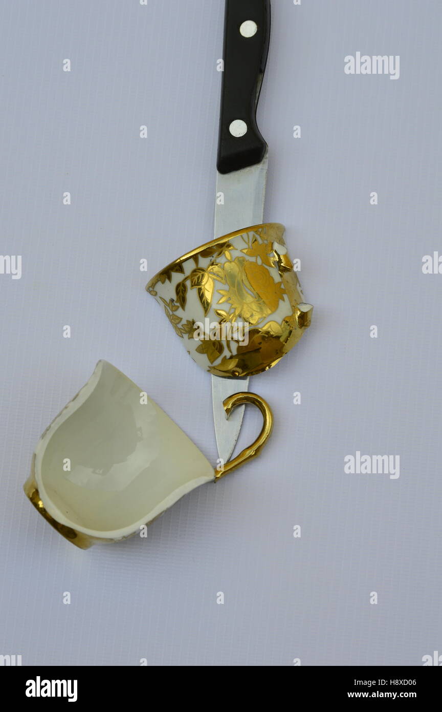 Broken cup of tea, and knife Stock Photo - Alamy
