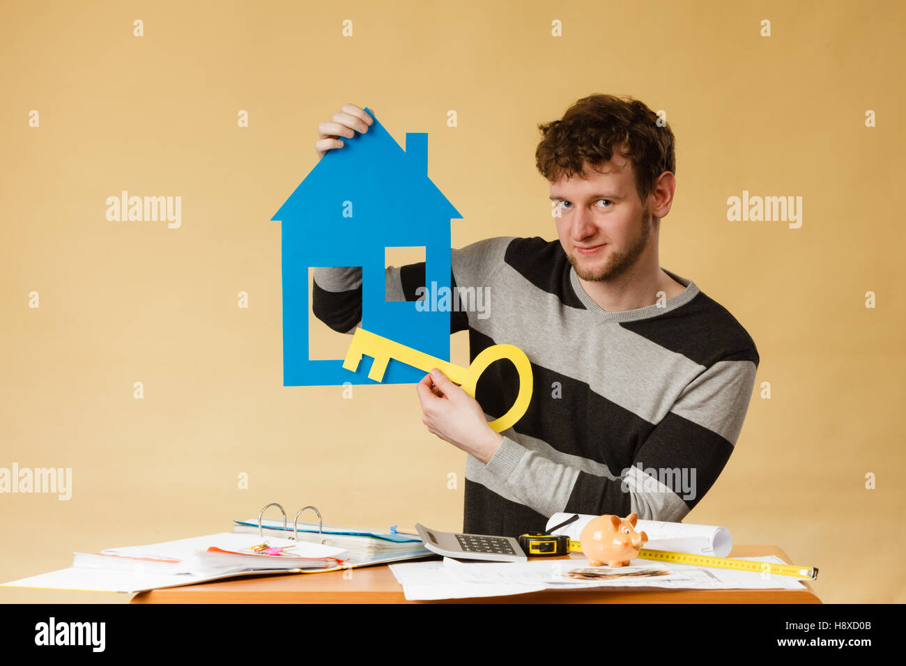 Good purchase concept. Male buyer with paper model of house and key ...