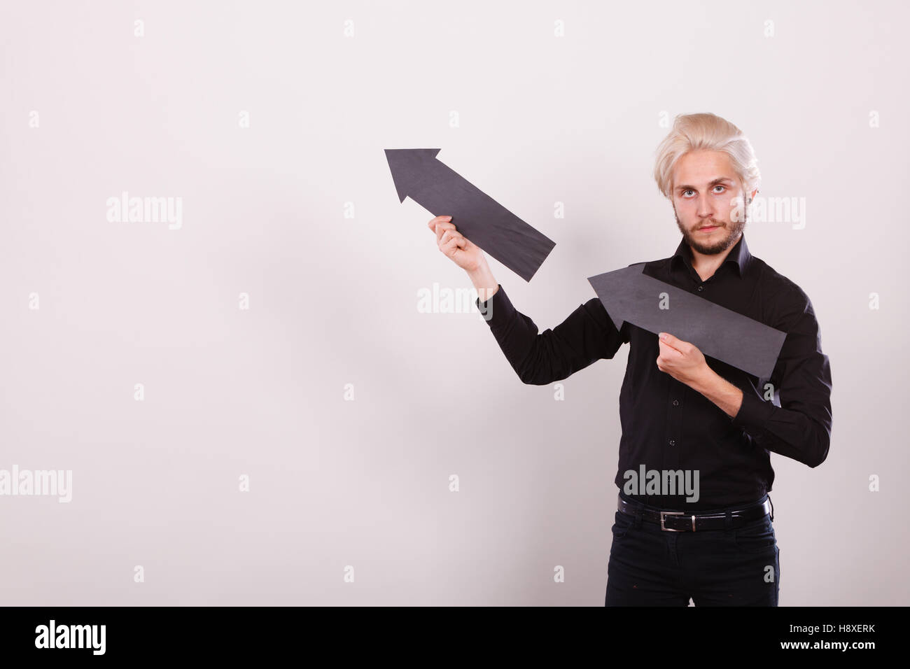 Planning, directions, choices concept. Man holding two black arrows ...