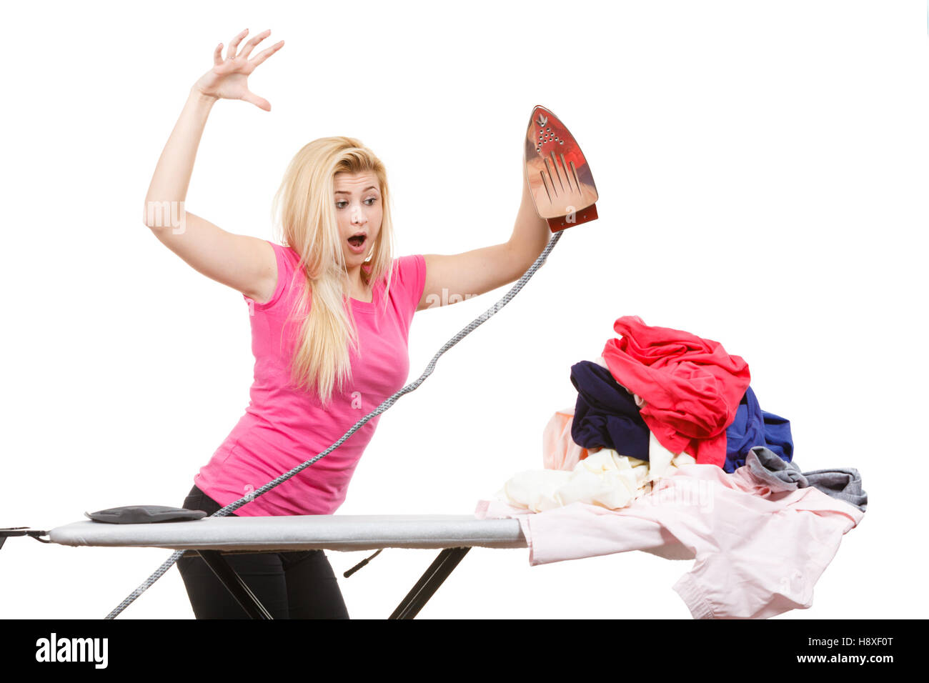 Housewife problems concept. Shocked angry woman standing behind ironing ...