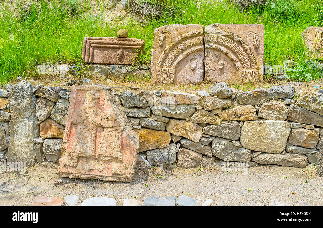 The ruined blocks and tombstones with preserved reliefs of people ...